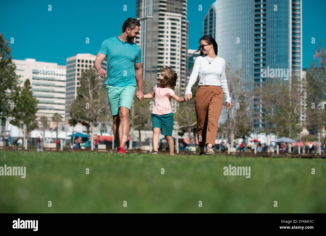 Parents with son walking in the city. Family taking a walk on street in ...