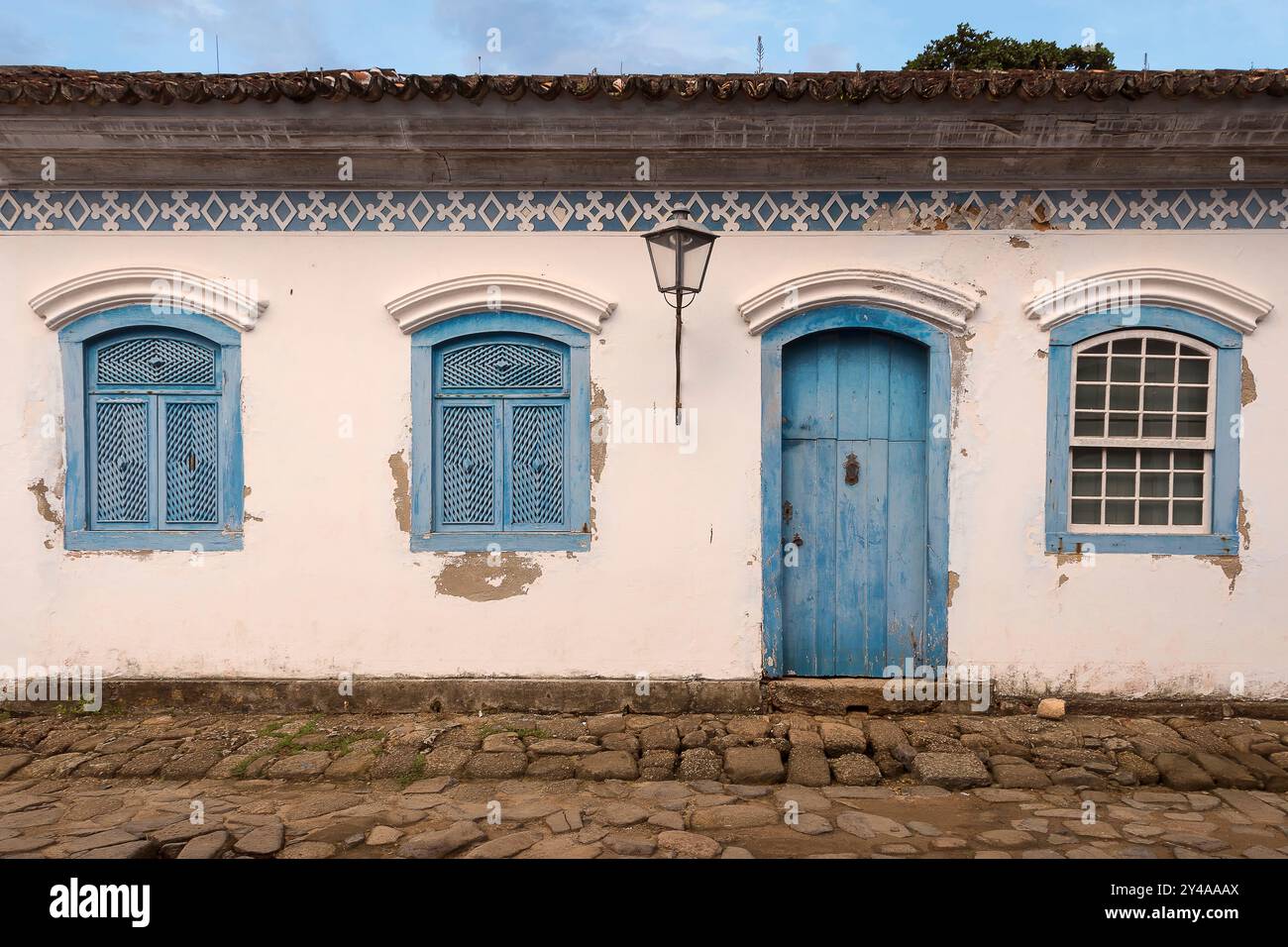 Paraty, Brazil. Old house facade from the colonial period. Wooden doors and windows with blue ...