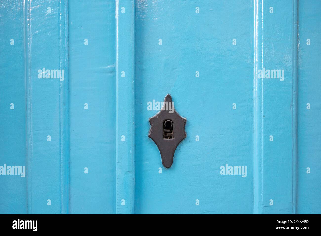 Old lock from the colonial period. Wooden door with blue paint. Space ...