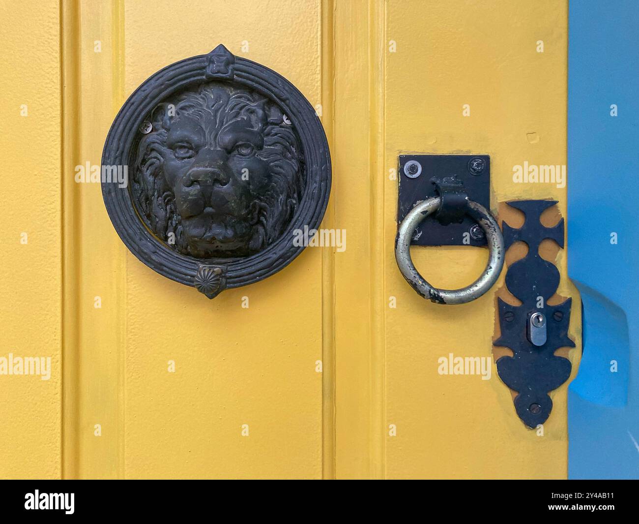 Old lock and knocker from the colonial period. Wooden door in yellow ...