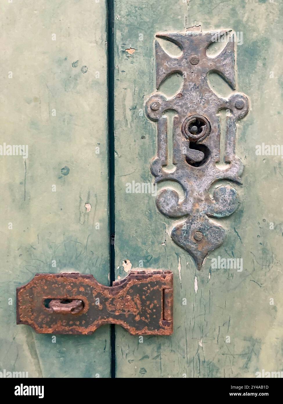Old lock from the colonial period. Wooden door with peeling paint ...