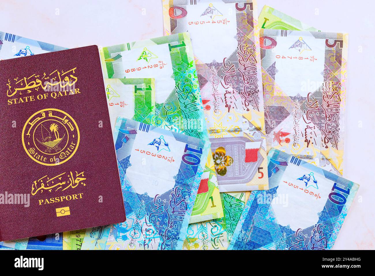 State of Qatar passport with is Qatari banknotes currency Riyals cash ...
