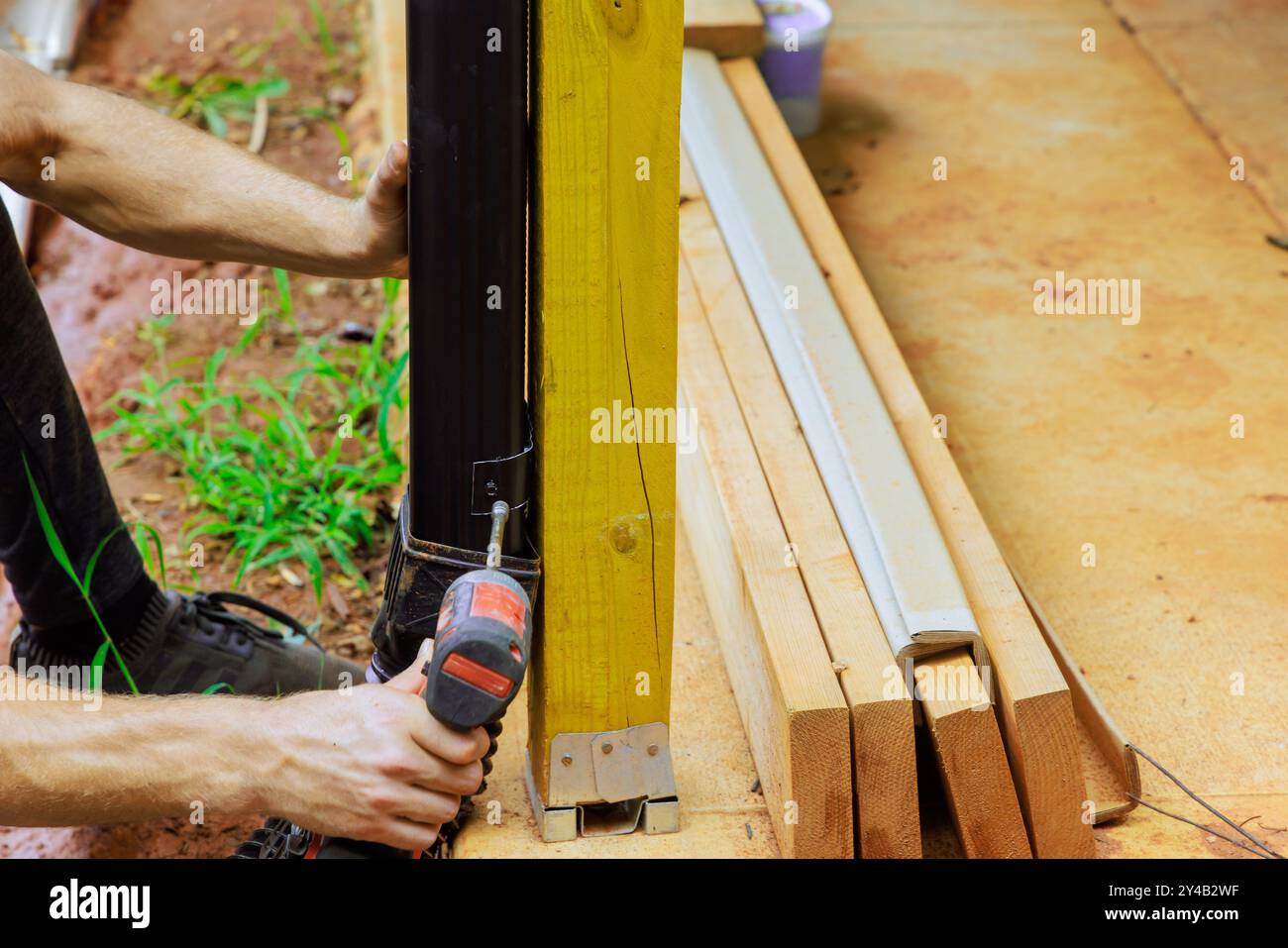 Handyman is assembling gutter channel that is attached to roof during ...