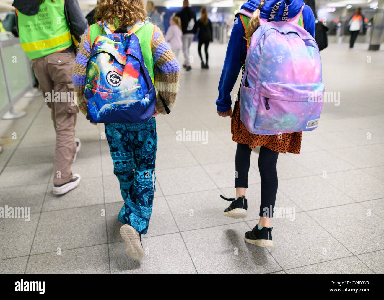 London, UK. Young girls wearing colourful backpacks in a tube station ...