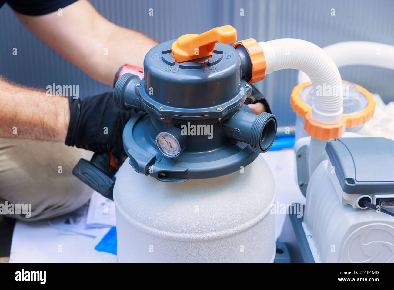 Worker assembling sand filter system tank, equipment for cleaning ...