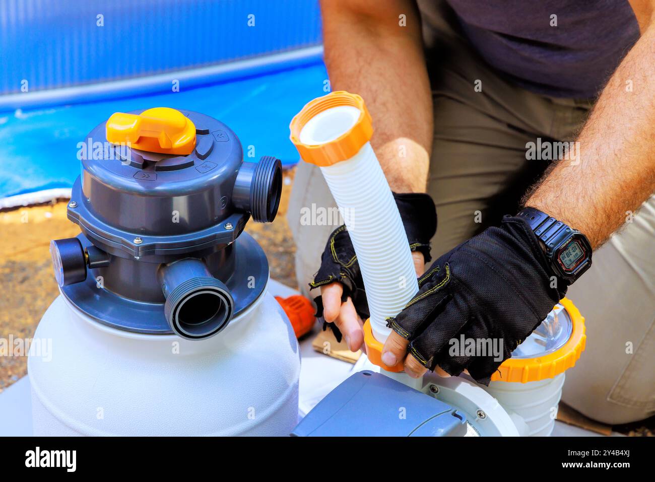 Maintenance worker assembles sand filter system tank well as cleaning ...
