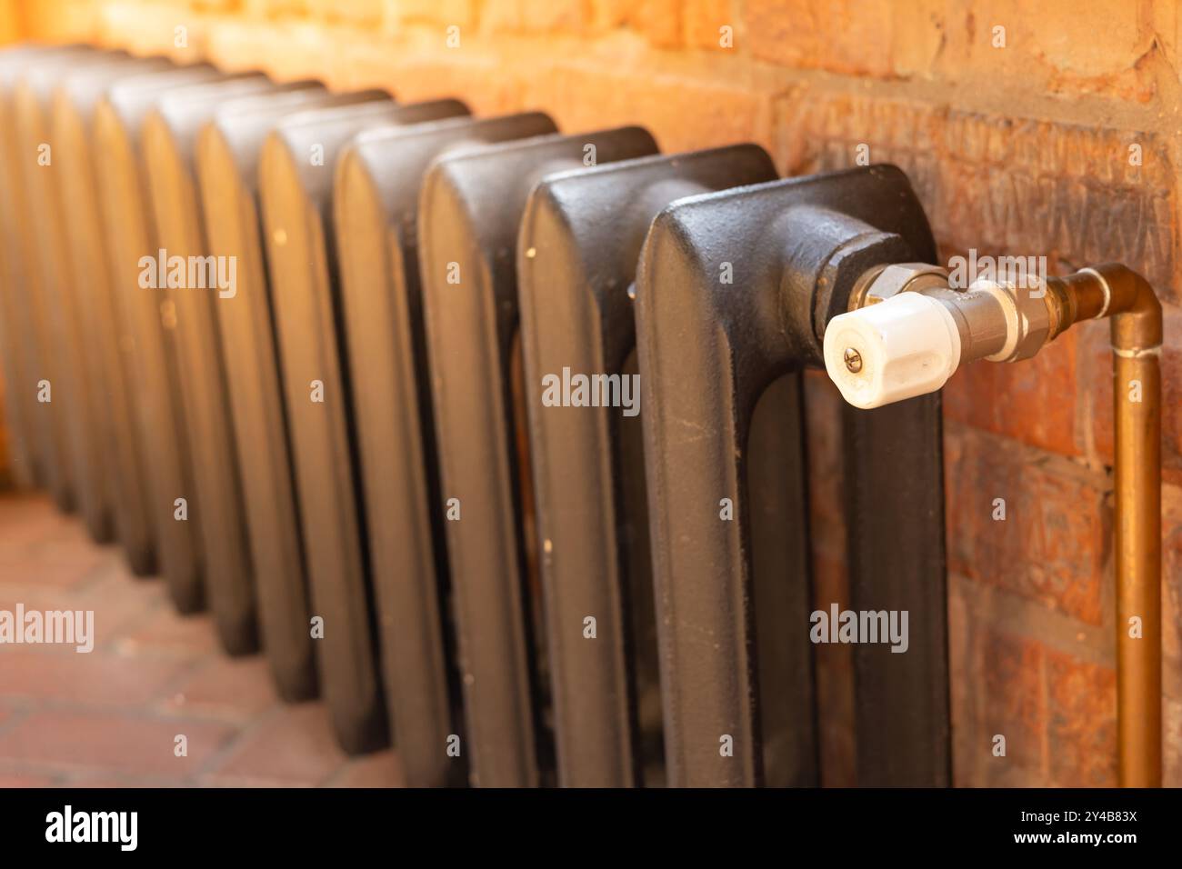 Classic metallic radiator installed in a cozy indoor space with exposed ...