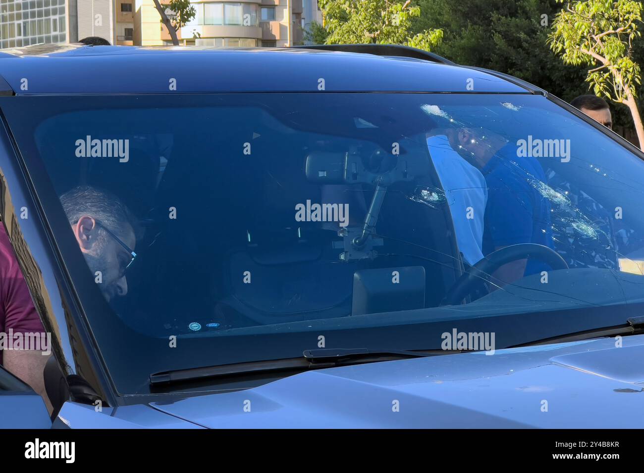 Police officers inspect a car inside of which a hand-held pager ...