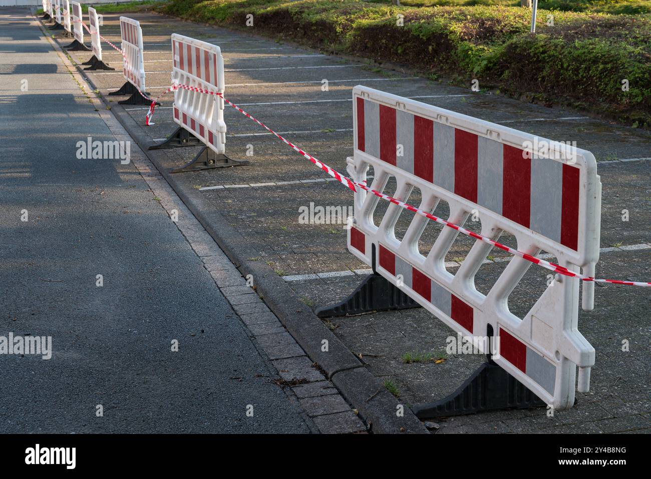 Road barriers and caution tape block off a section of a parking area ...