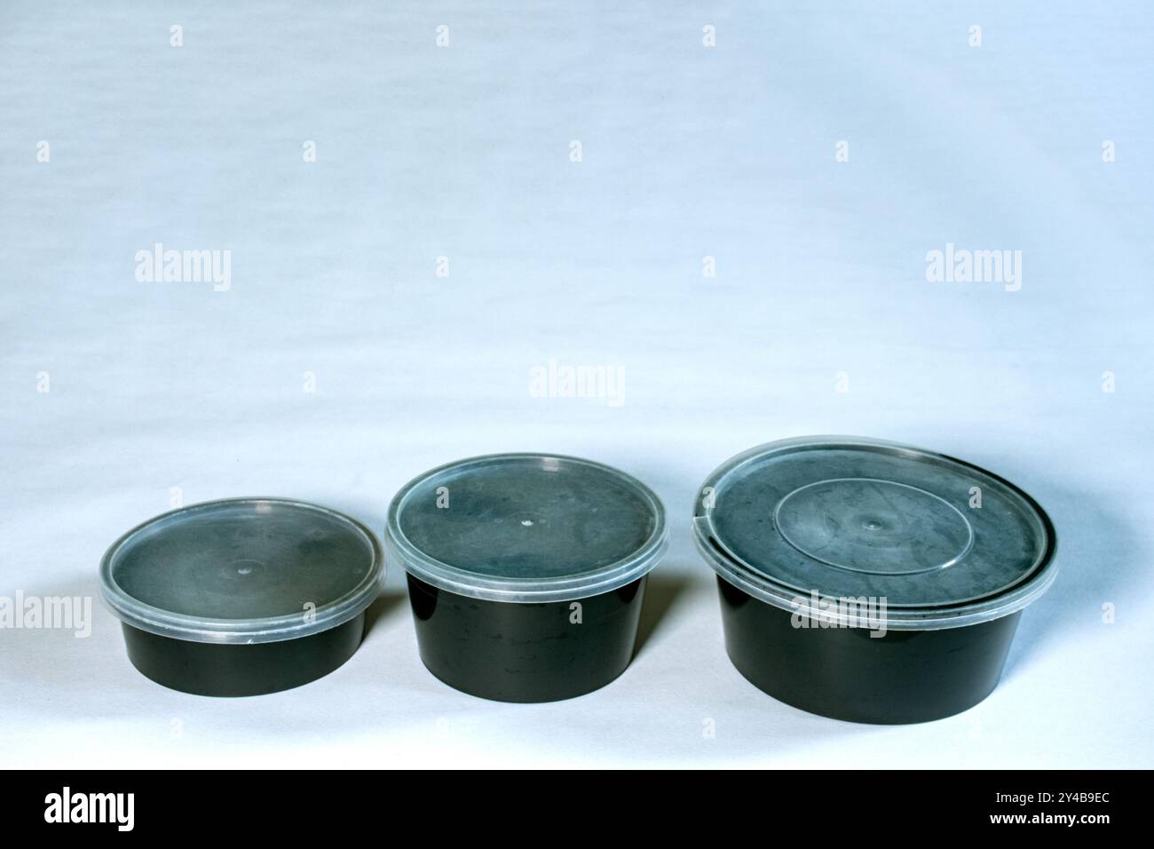 Set of three black food-grade round-shaped plastic containers with ...