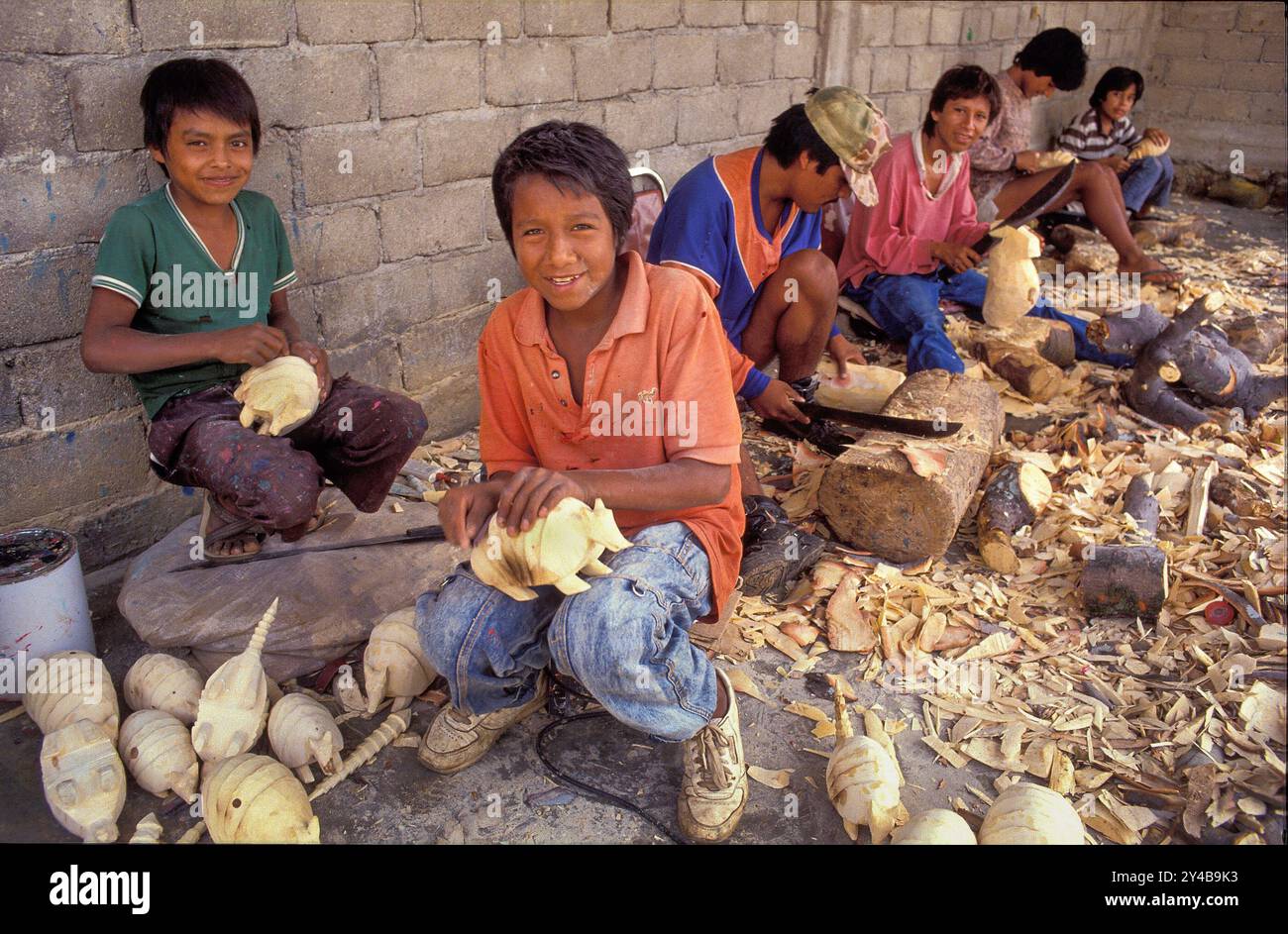 Mexico, Oaxaca. Children producing souvenirs for tourists in a wood ...