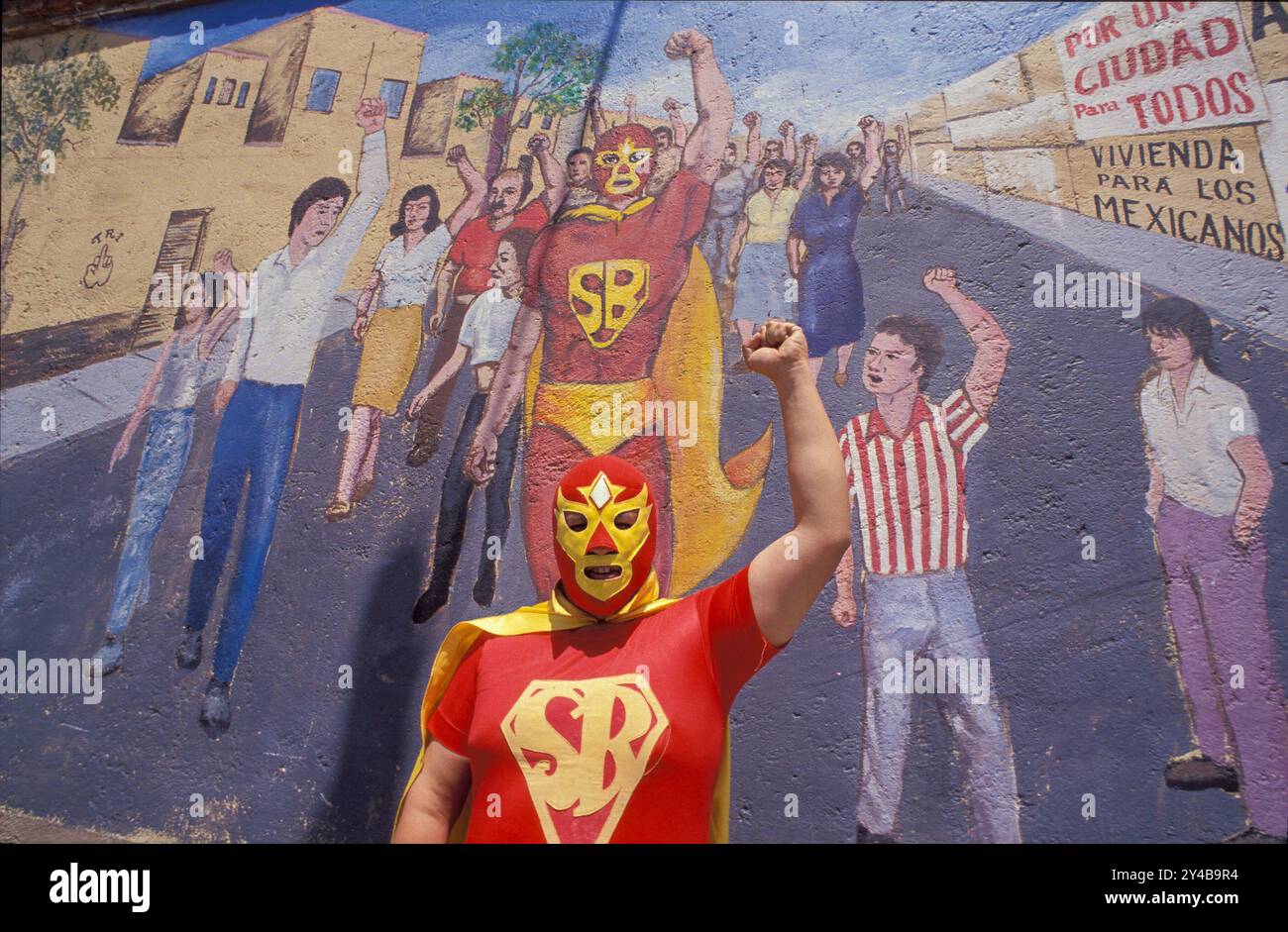 Mexico, Mexico City. Super Bario posing in front of a mural of himself ...