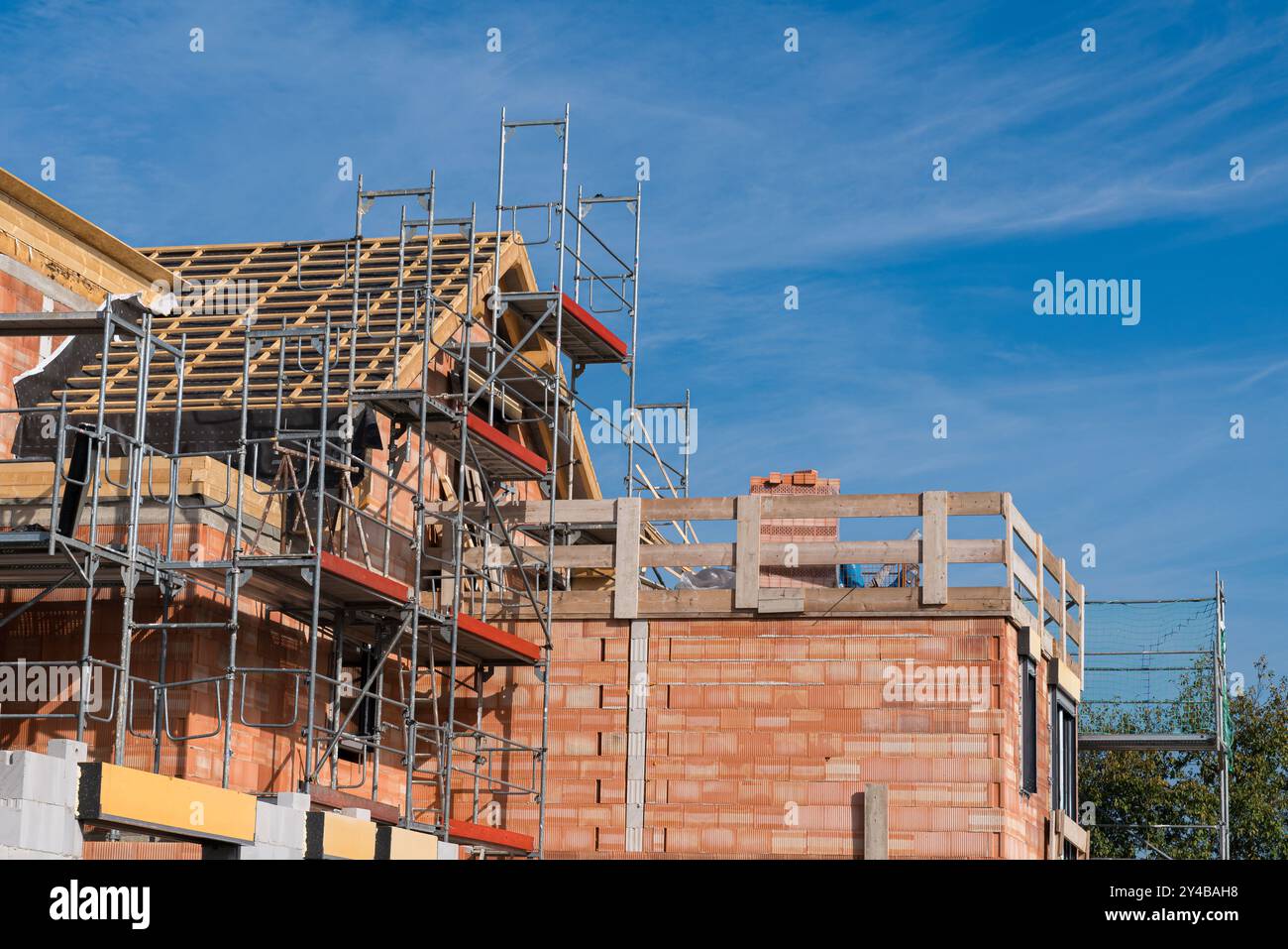 A construction site displays scaffolding attached to brick walls ...