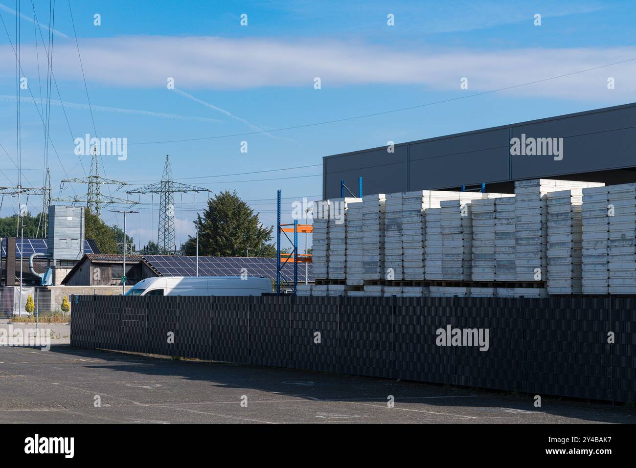 A storage area features stacks of concrete blocks beside a large ...