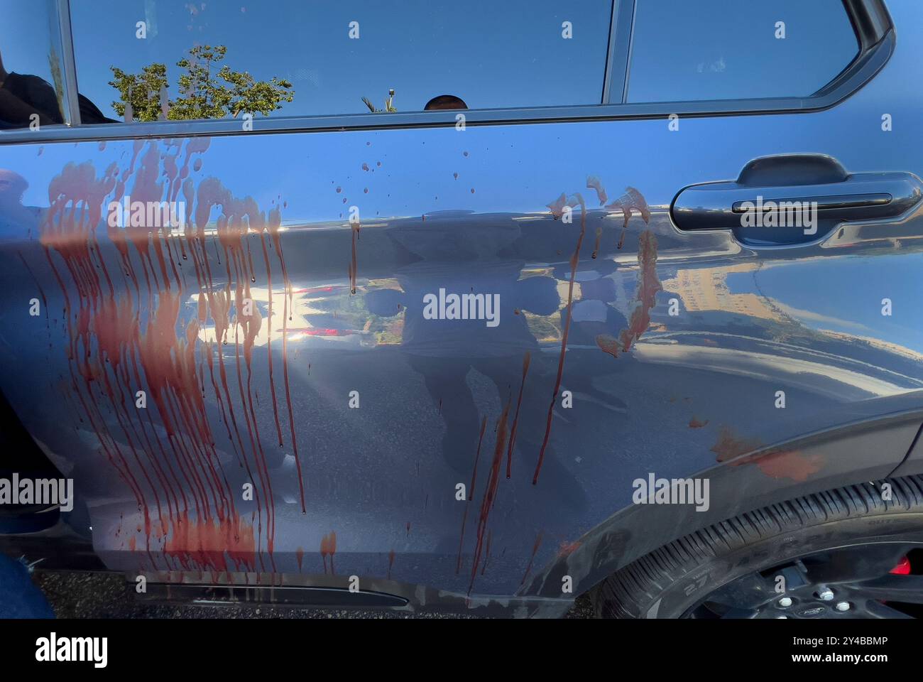 The blood of an injured man is seen on his car's door after a hand-held ...