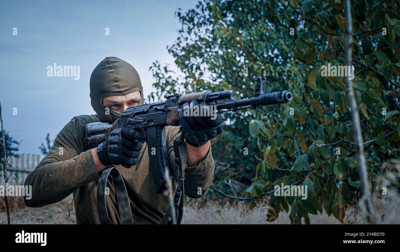 A professional military officer loads his armor and aims his machine ...