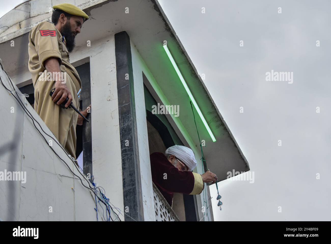 A policeman (L) stands alert as a head priest (R) displays the holy ...