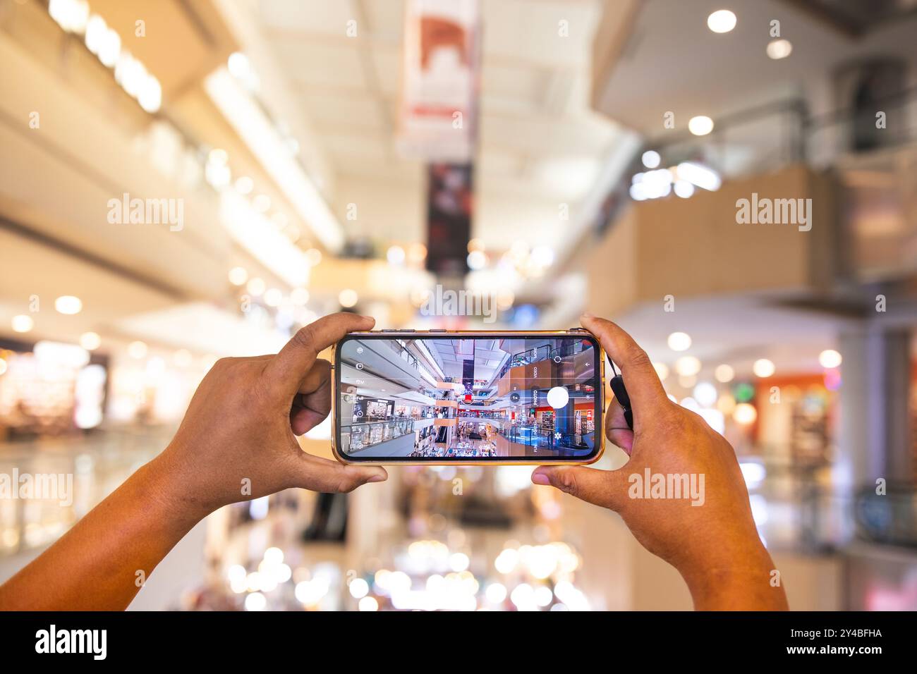A man taking photo of supermarket with Smartphone. the man is seen ...