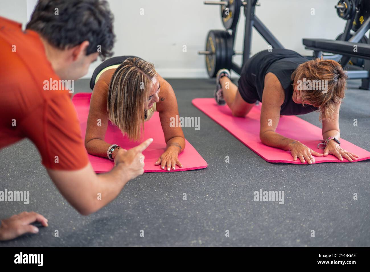 closeup In a gym setting, two mature women are engaged in plank ...