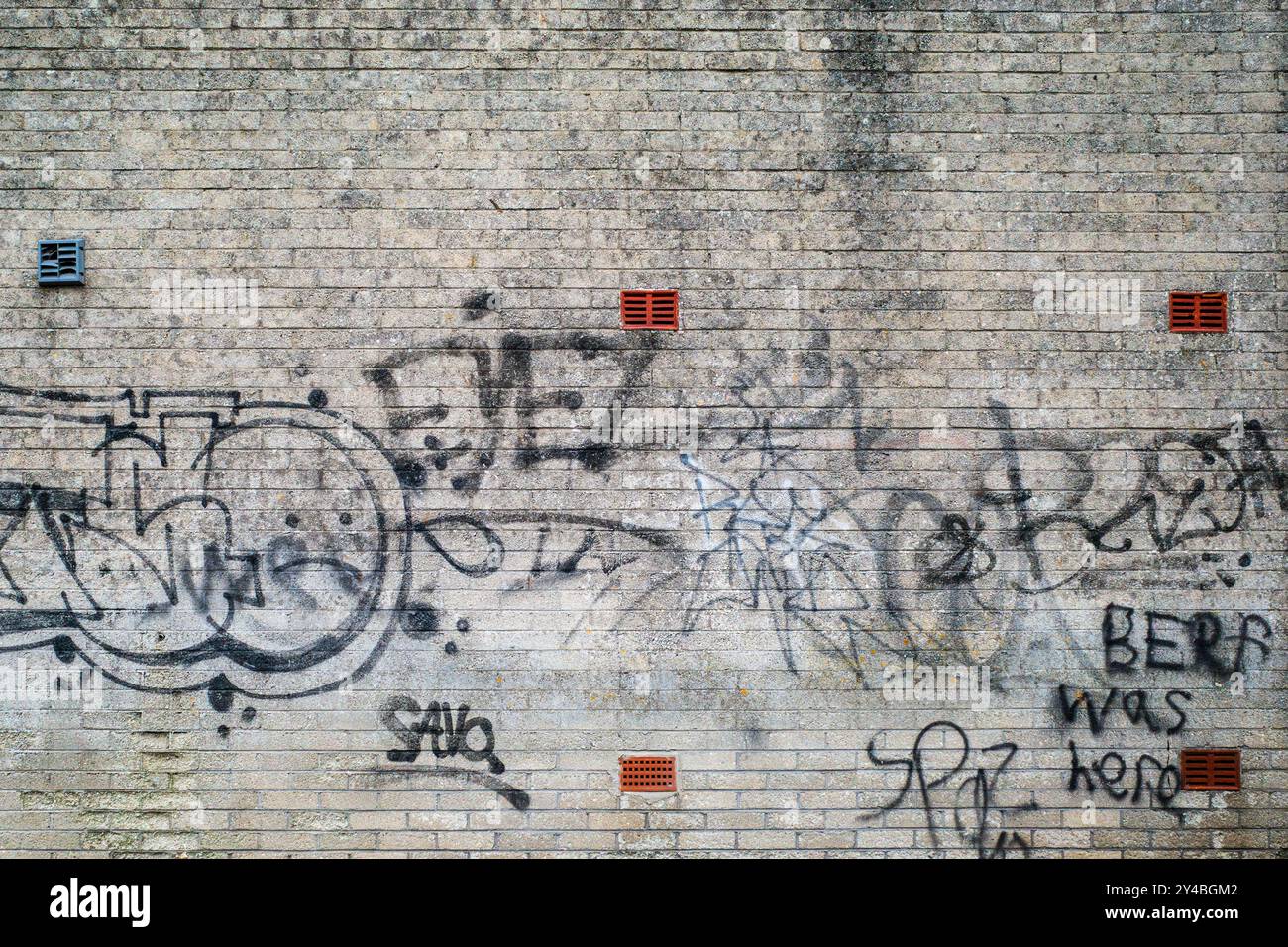 A brick wall covered in ugly graffiti in Newquay town centre center in ...