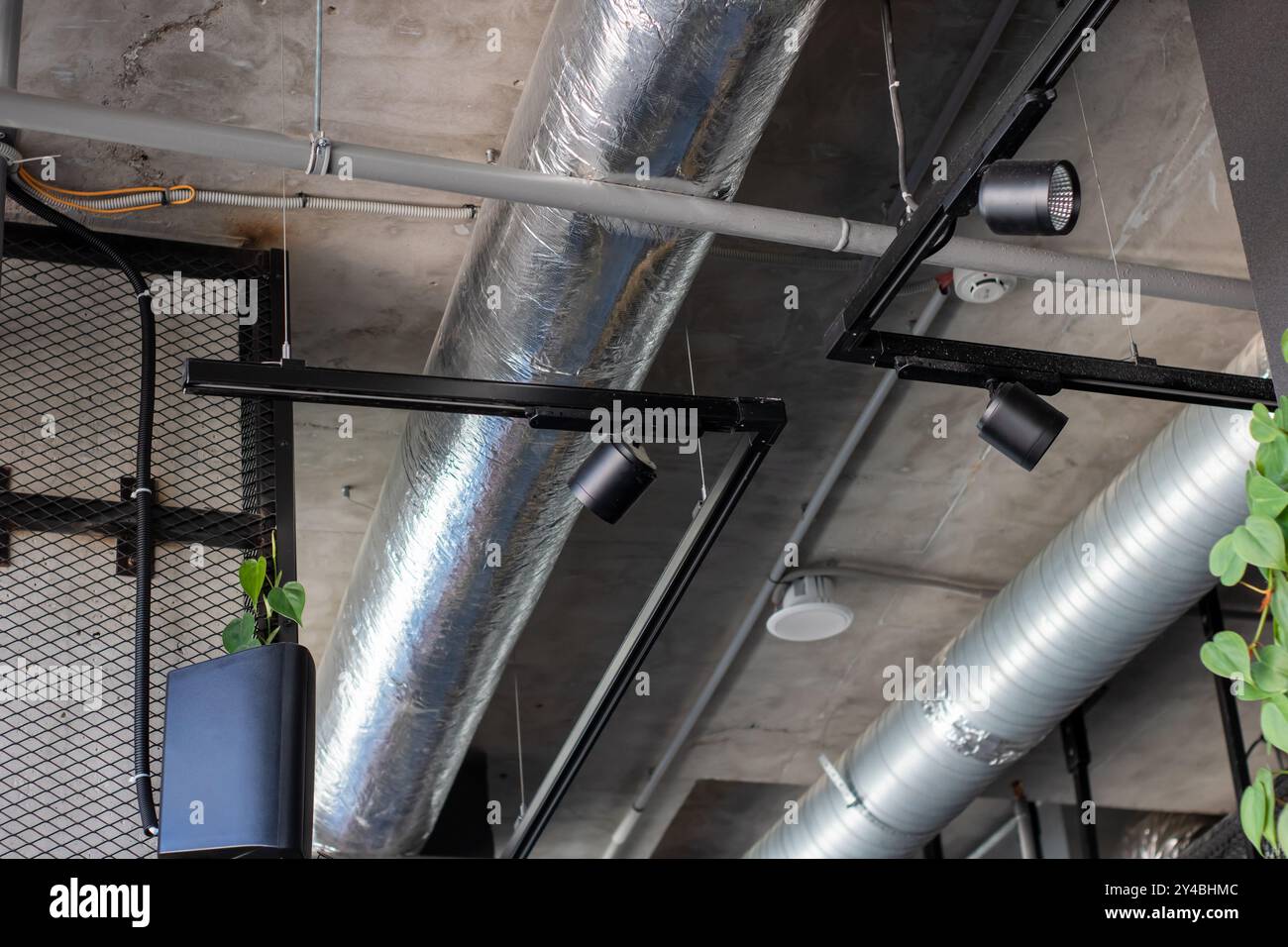 A ceiling that features a complex arrangement of numerous pipes and ...
