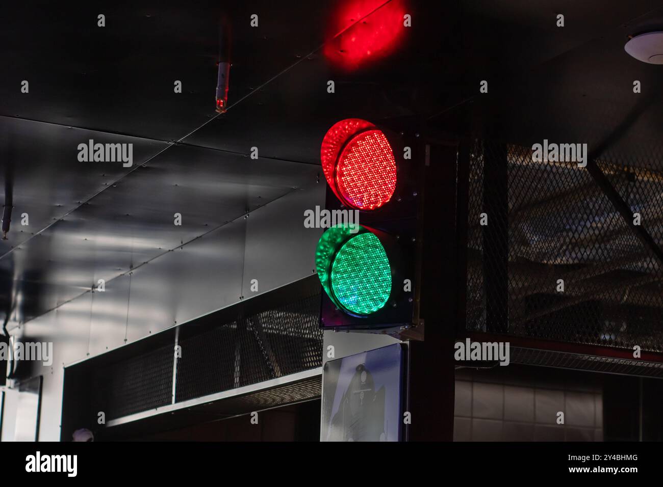 In a dimly lit, dark room, there is a red and green traffic light ...