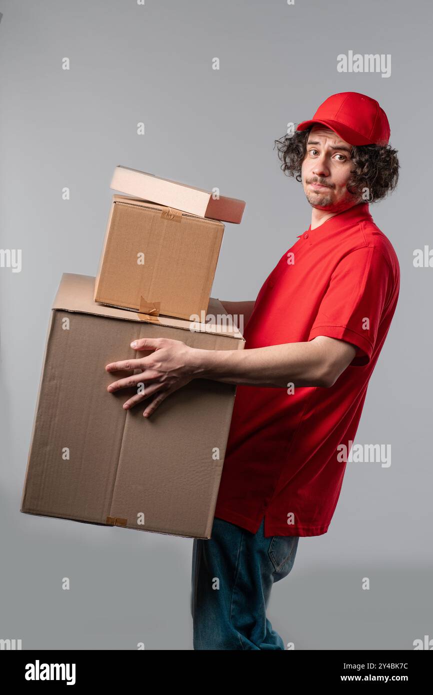 Postal courier man with heavy parcels boxes. Postman delivers address ...