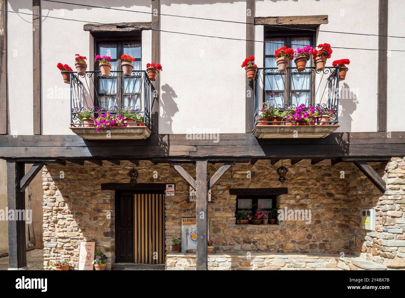 A typical house in Yanguas features colorful flower boxes that enhance ...