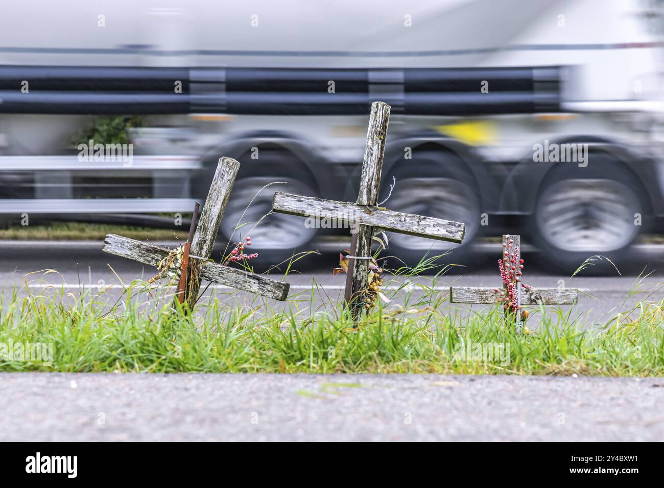 Cross on a country road, symbol of remembrance for three road accident ...