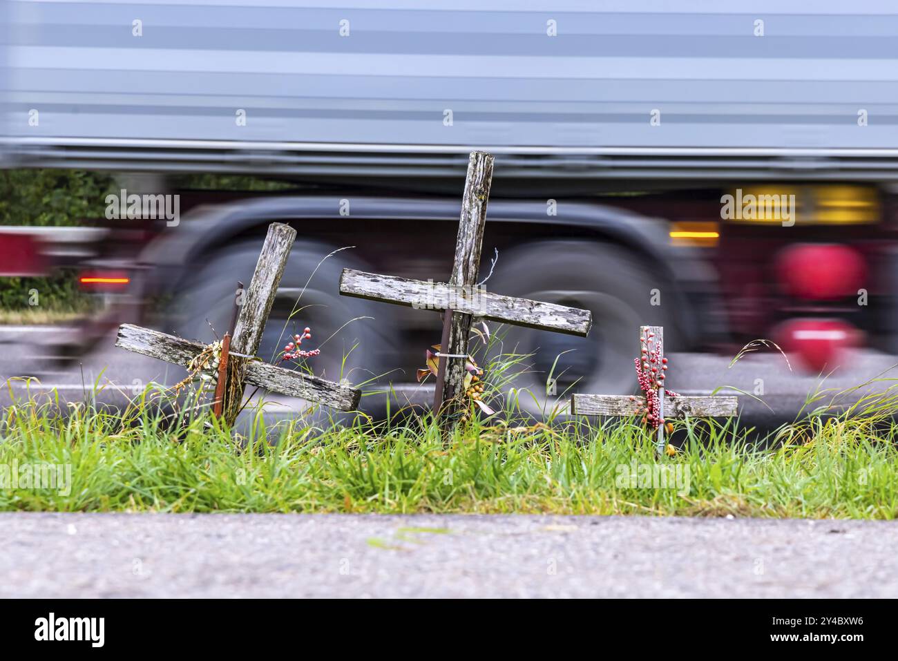 Cross on a country road, symbol of remembrance for three road accident ...