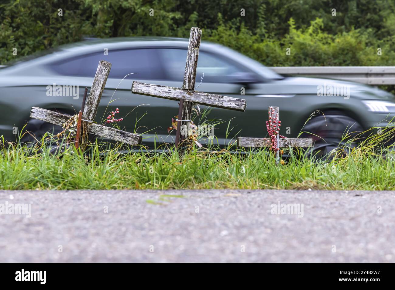 Cross on a country road, symbol of remembrance for three road accident ...