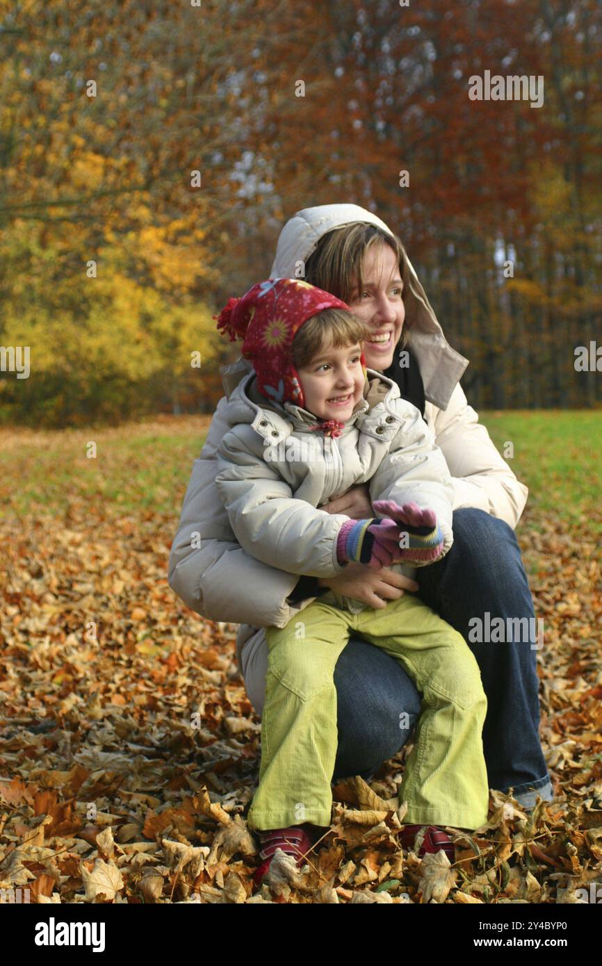 Mother and daughter sitting in a park, Federal Republic of Germany ...