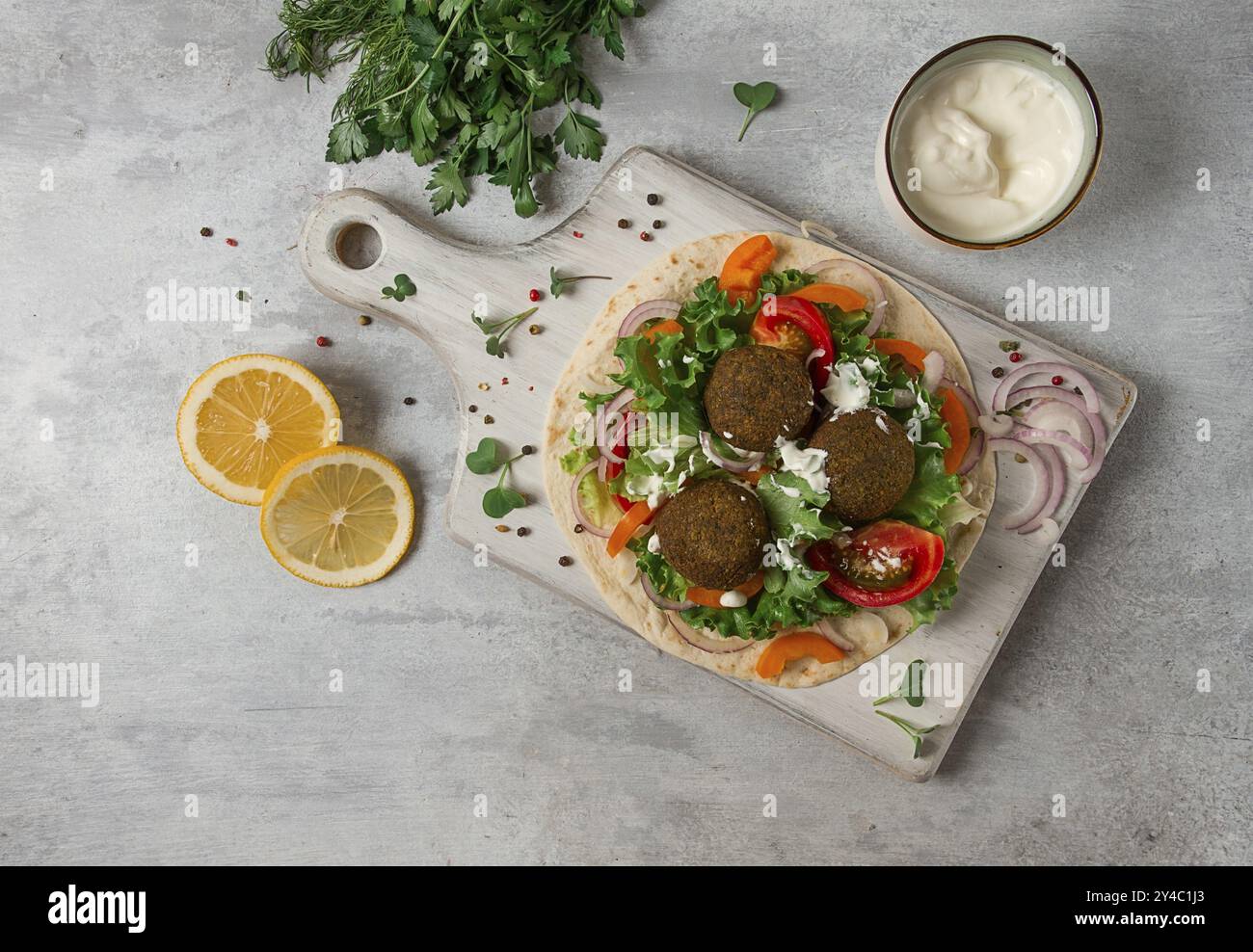 Tortilla with falafel and vegetable salad, white sauce, Arabic cuisine ...
