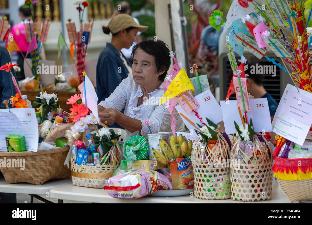 A devotee is preparing items for making merit during the festival at ...