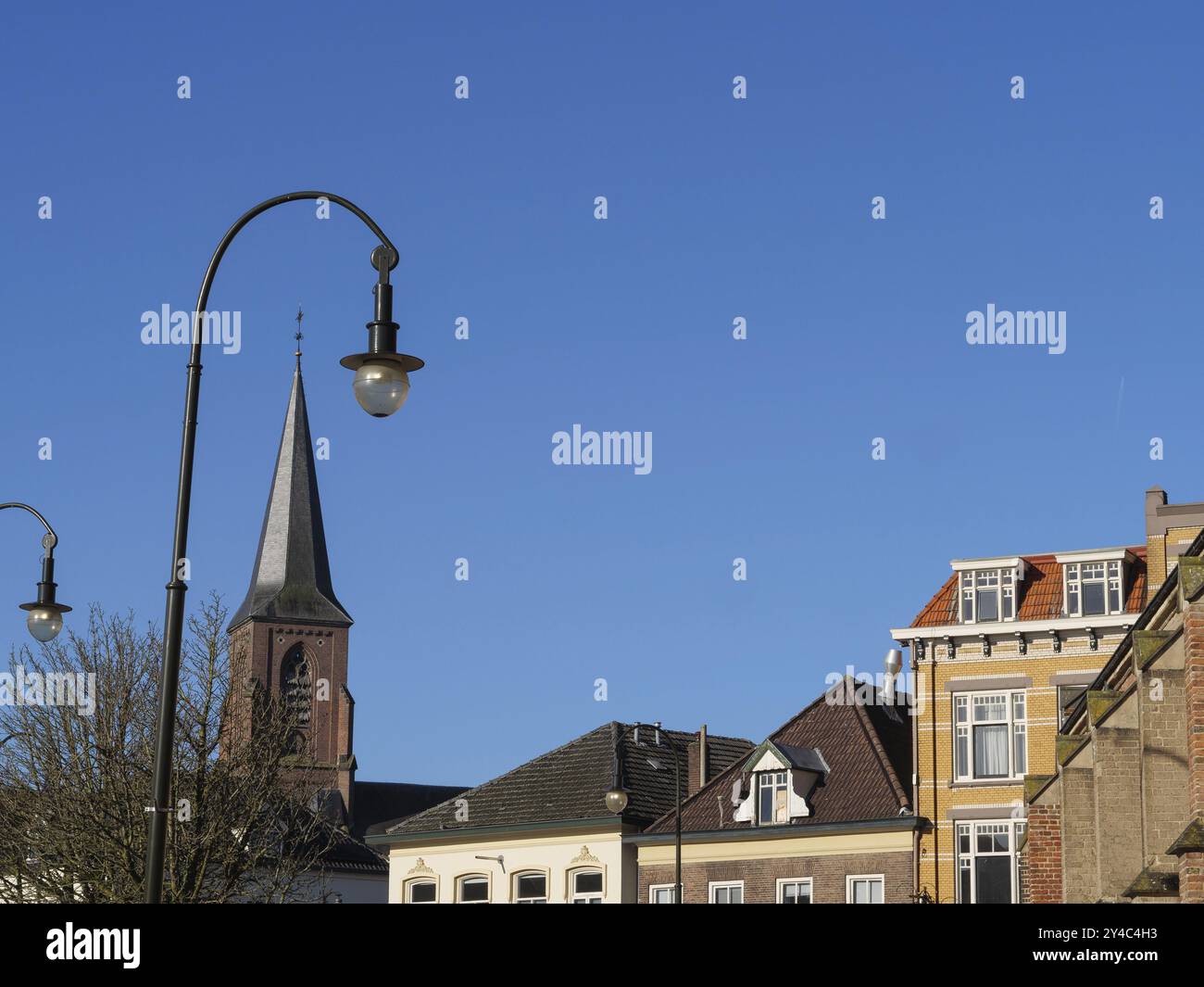 Bright blue sky over city buildings and church tower, winterswijk, the ...