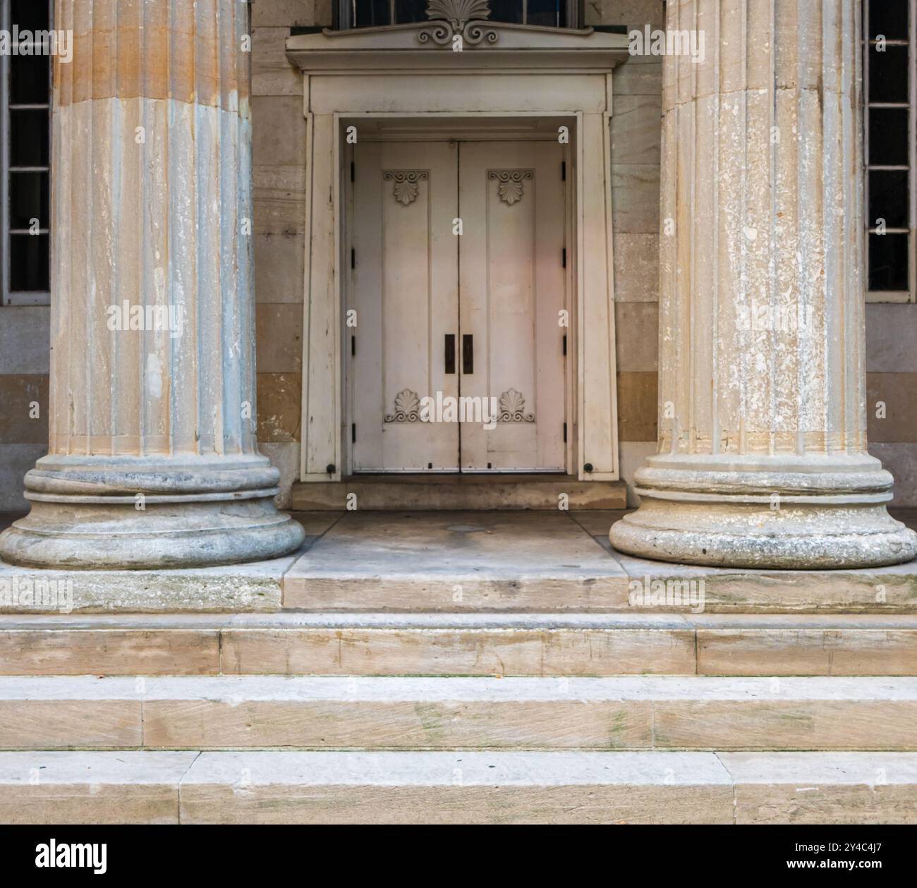 Antique doors flanked by large fluted columns at top of short stairway ...