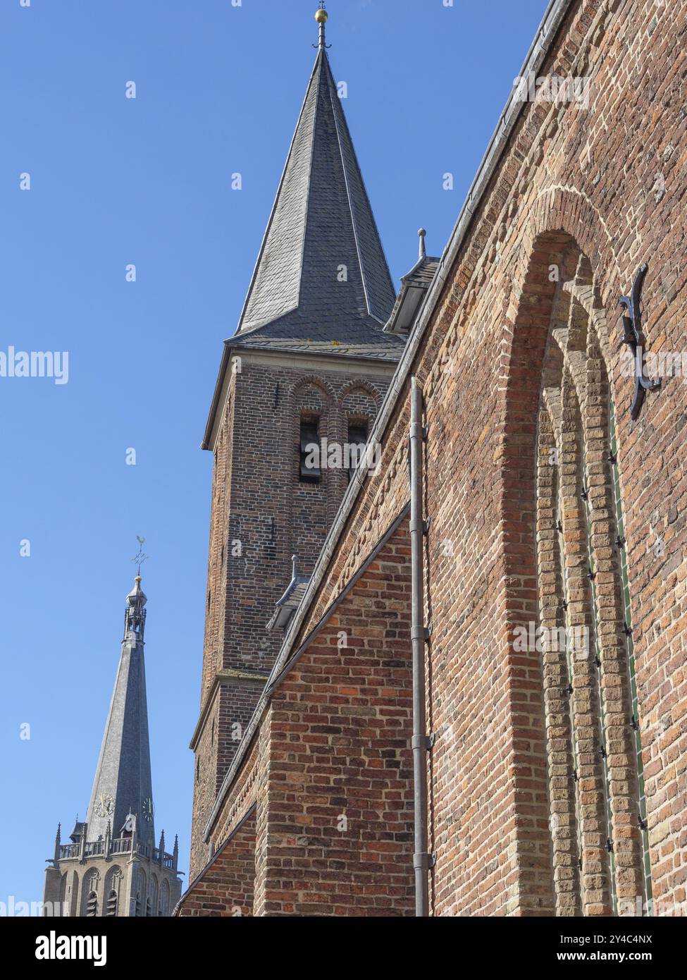 Detailed view of a church tower with brick structure under a clear sky ...
