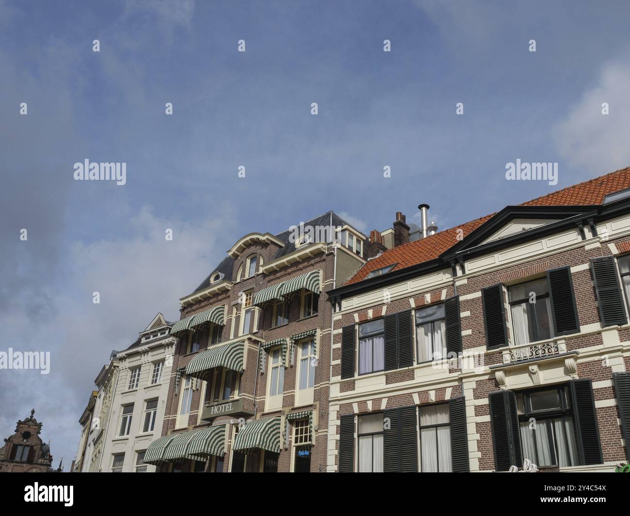 Historic houses with decorated facades and tiled roofs under a cloudy ...