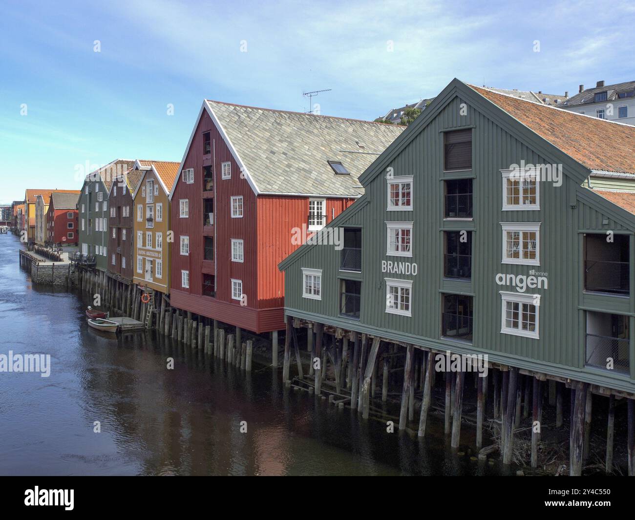 Colourful historic riverside buildings built on stilts under a blue sky ...