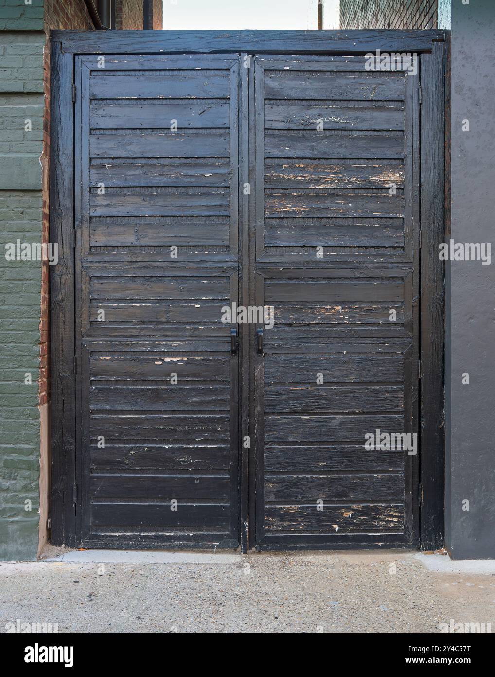 Antique wooden doors closing alleyway between two brick buildings Stock ...