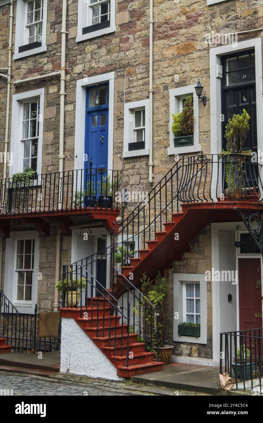 Urban terraced houses with colourful doors and stairs, lined with ...