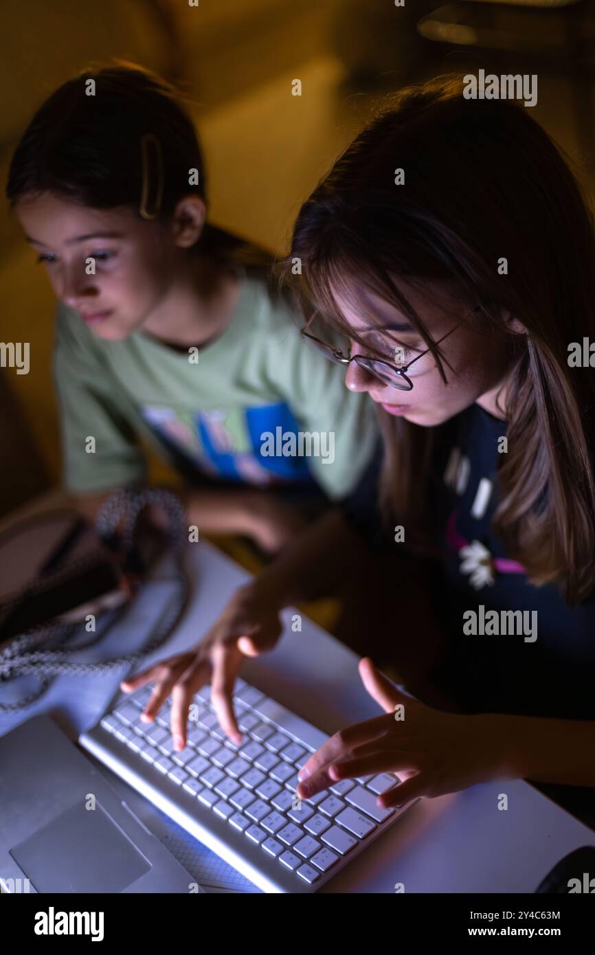 Two young girls at the computer at night Stock Photo - Alamy