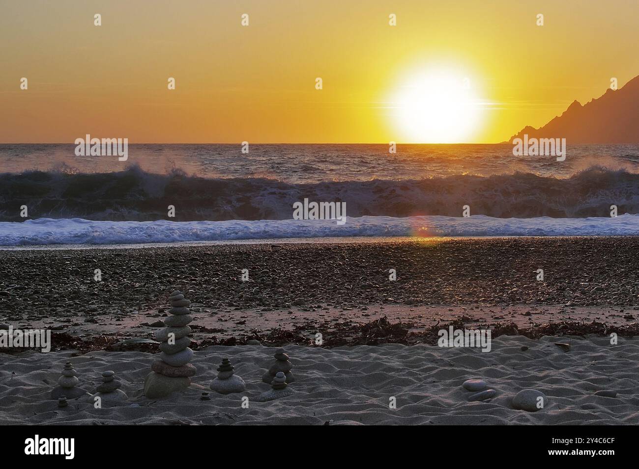 Land art in front of surf waves at sunset on Porto beach, Corsica Stock ...