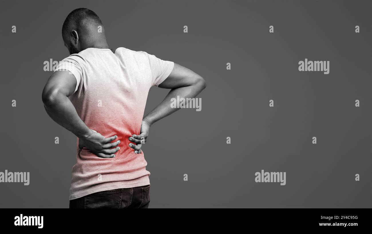 Black man holding his hands on lower back Stock Photo - Alamy