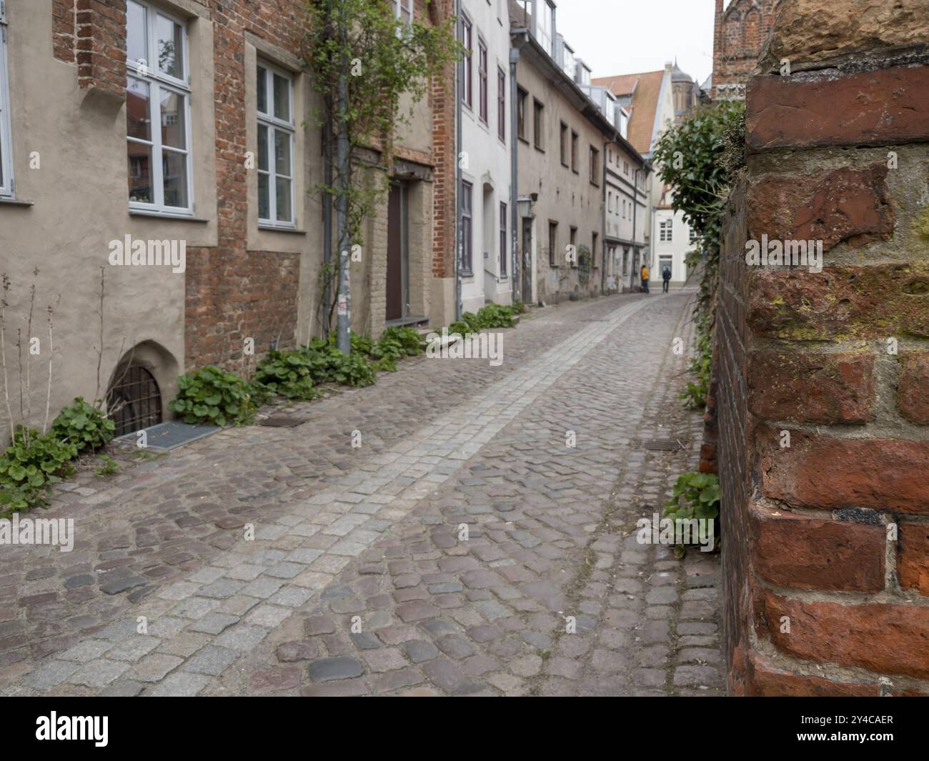 Plain cobblestone alley in an old town with various buildings ...