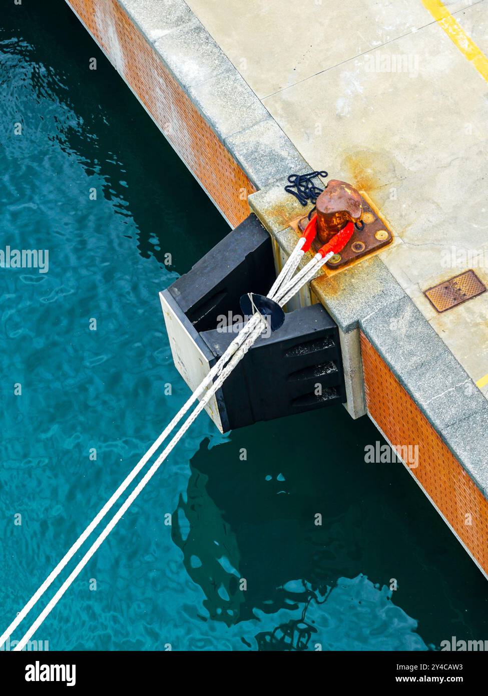 A tense stretched ship's thick mooring ropes at the mooring pole of the ...