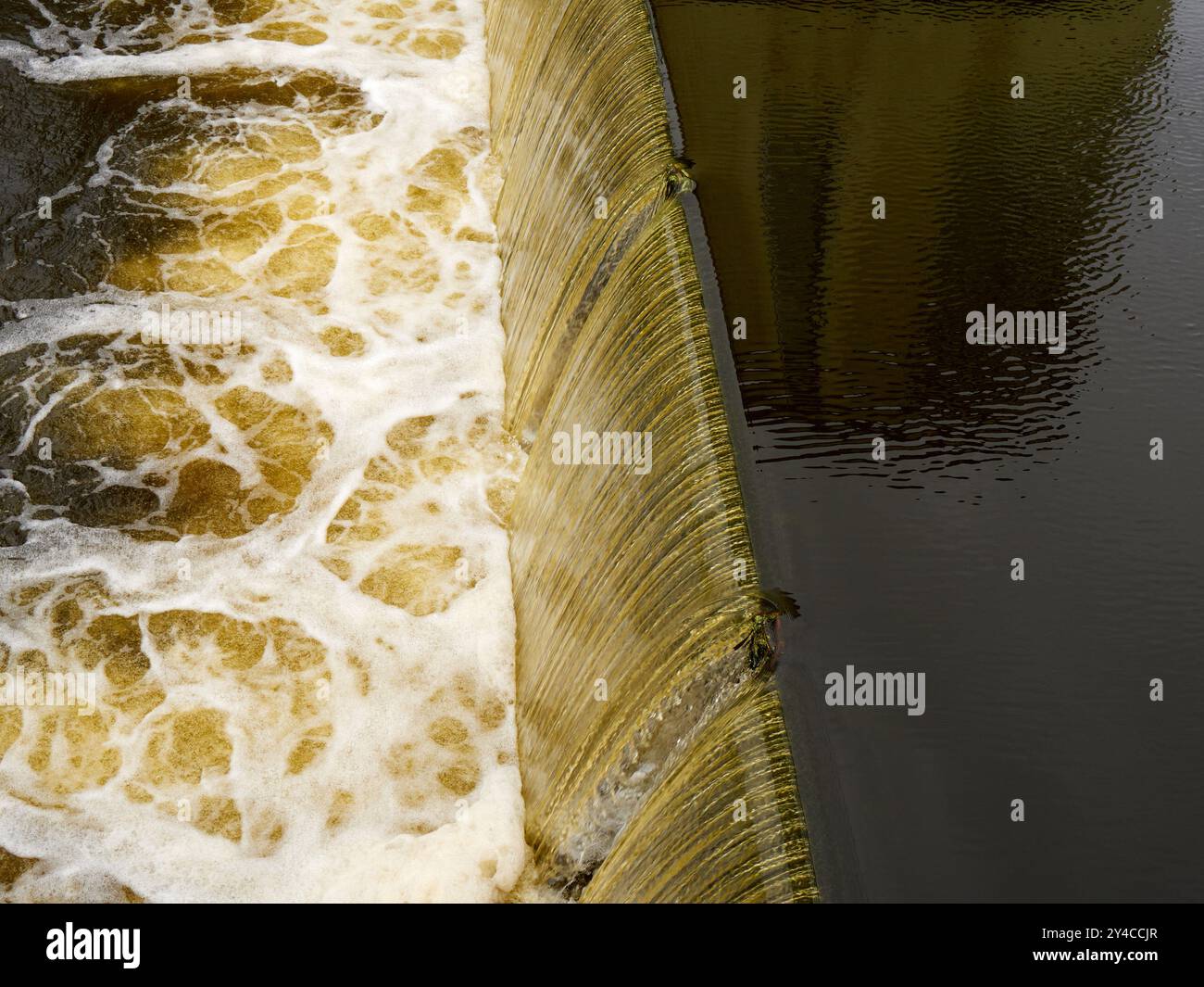 Water in the river overflowing through a weir Stock Photo - Alamy