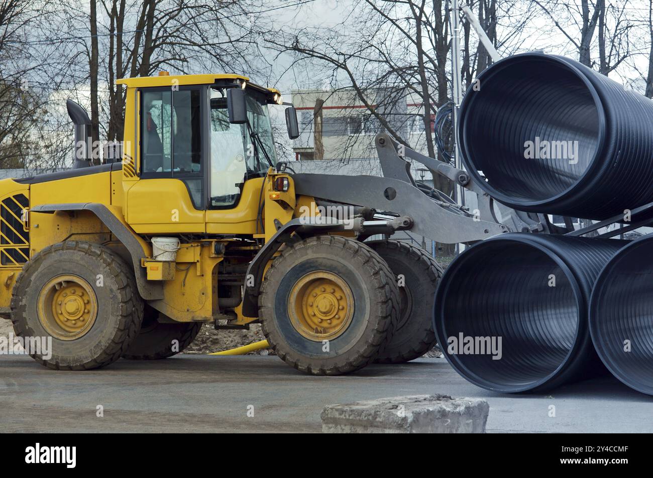 Forklift distributes plastic pipes of large diameter Stock Photo - Alamy