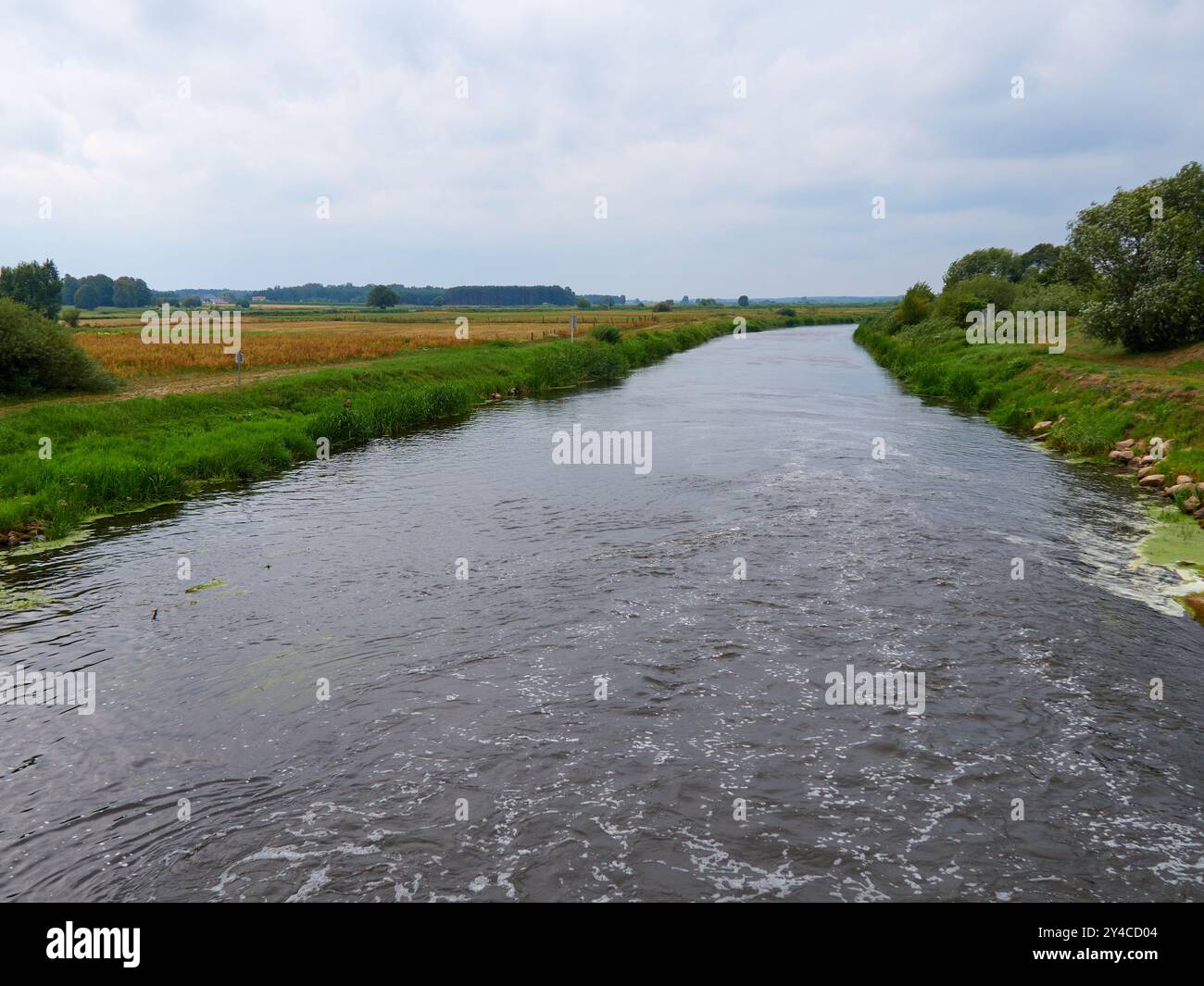 a river flowing between green fields Stock Photo - Alamy