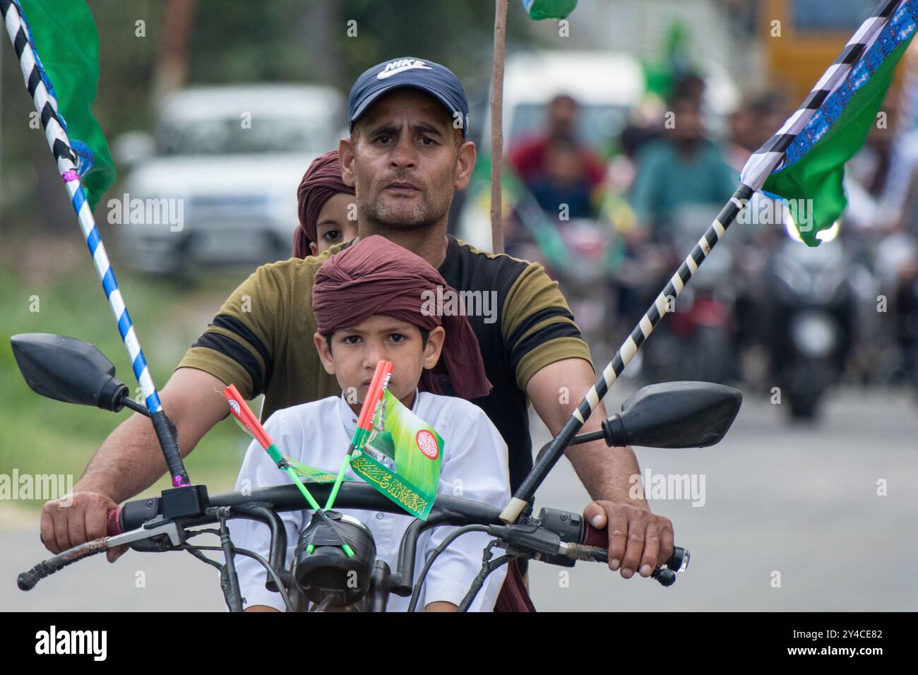 A Kashmiri Muslim seen on his motorcycle with Islamic flags as they take part in a religious ...